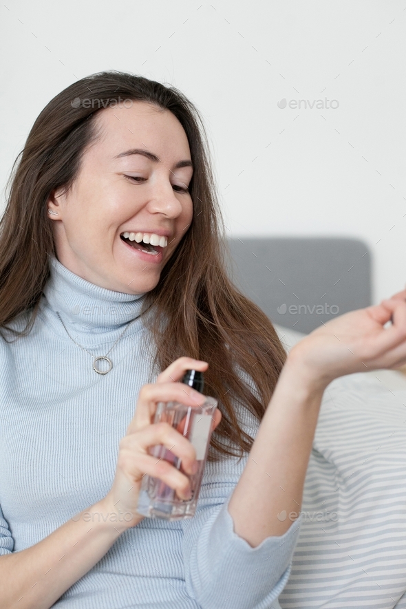 Woman using perfume, applying perfume on her skin, happy, happy people ...