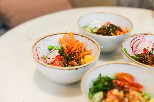 Plates with poke bowls on the white table, asian cuisine, healthy ...