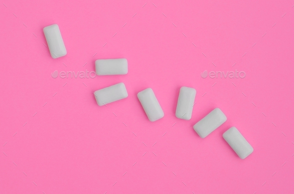 A few chewing gums lie on texture background of fashion pastel pink ...
