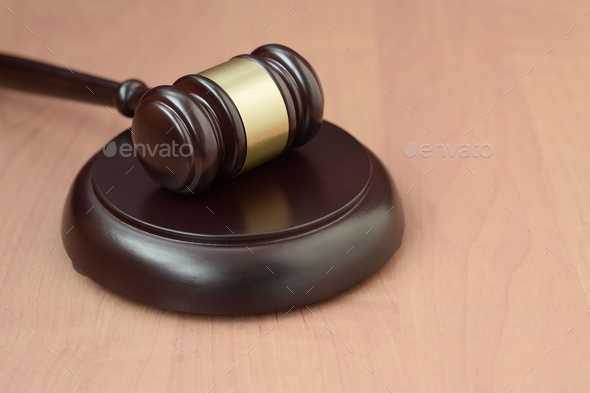 Justice mallet on wooden desk in a courtroom during a judicial trial. Law concept and empty ...