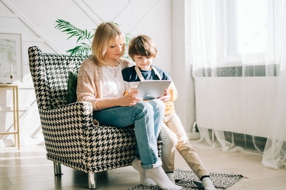 Grandma with child kid boy and tablet laptop. Family together online at ...