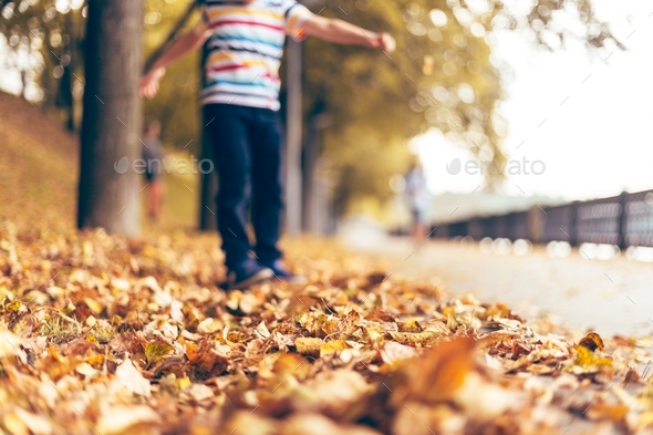Blurred autumn background defocus.Child walking road with falling ...