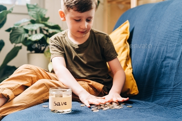 Child save money, put coin in glass jar. Kid boy putting money in money ...