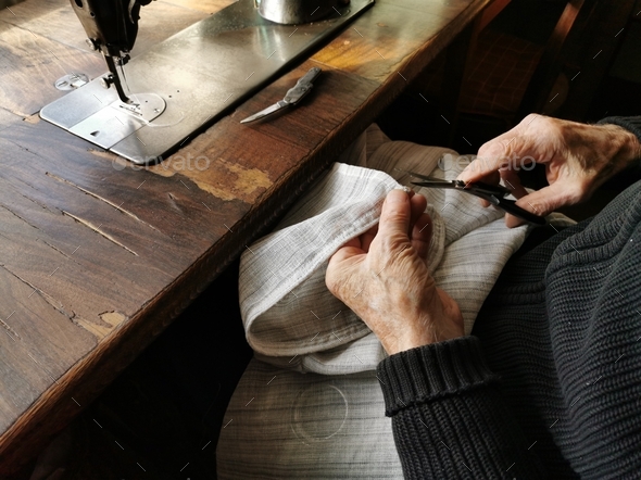 Close-up of old man sewing. Person sitting behind a sewing machine ...