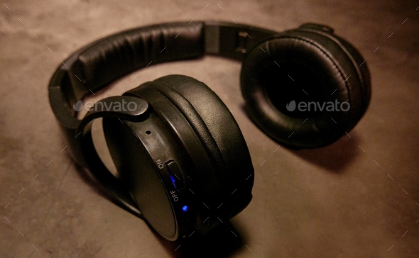 Close-up image of Black wireless bluetooth headphones with a led blue ...