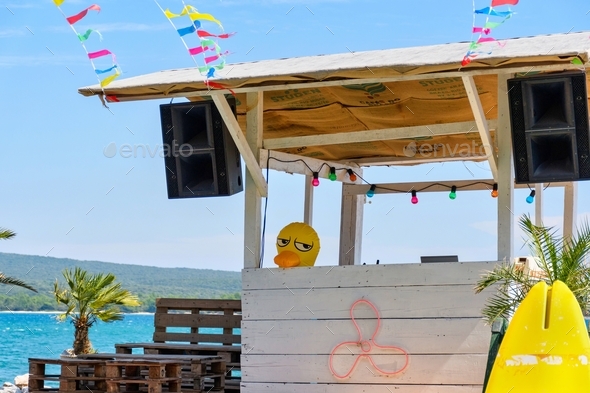 Funny photo of an inflatable duck behind a DJ counter in a beach bar ...