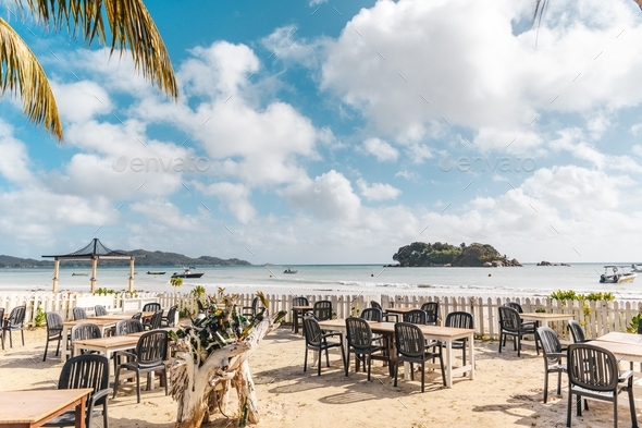 Empty terrace of a beach bar on Tropical sandy beach under blue sky ...