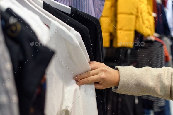 Selective focus of woman shopping in retail store. Hand touching ...