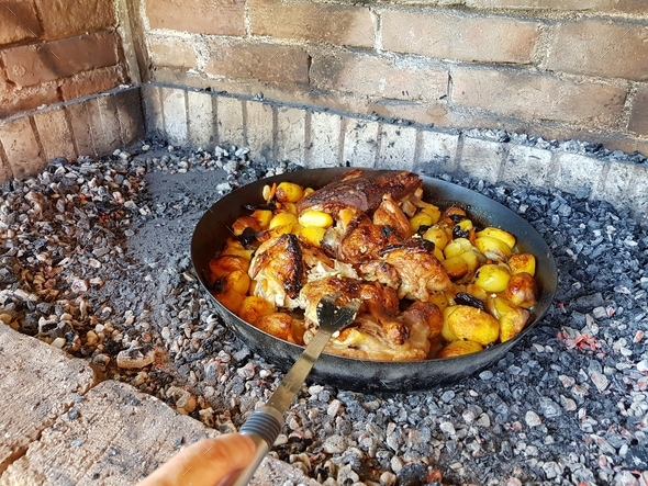 Open fire and ember roast. Brick oven barbecue. Meat and potatos. Stock ...