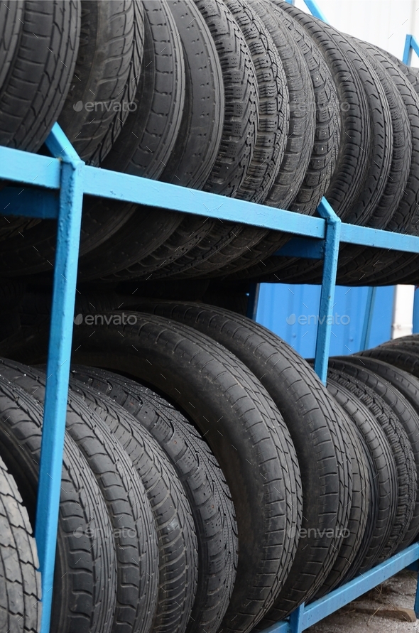 Rack with variety of car tires in automobile store. Many black tires ...