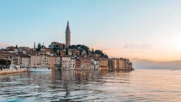 Sunset over ocean behind a picturesque seaside town in Rovinj, Croatia ...