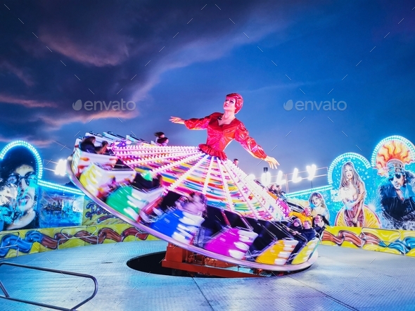 Colorful spinning carnival ride called wipeout or trabant, illuminated ...