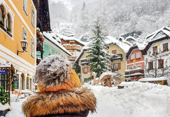 Rear view of woman wearing knit hat in colorful snow covered town in ...