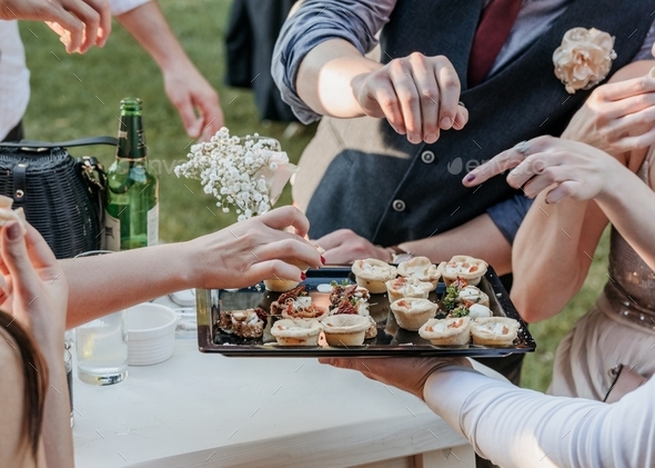 Group of friends eating finger food at a wedding reception Stock Photo ...