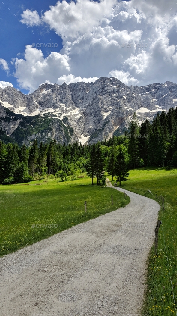 Empty dusty road in a valley surrounded by mountains. Breathtaking view ...