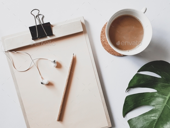 Flat lay photo of pastel colors stationery on a white desk with cup of ...