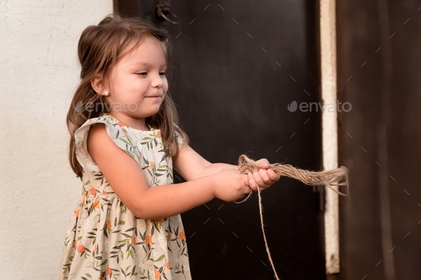 Little girl playing with jute threads Stock Photo by natanavo | PhotoDune