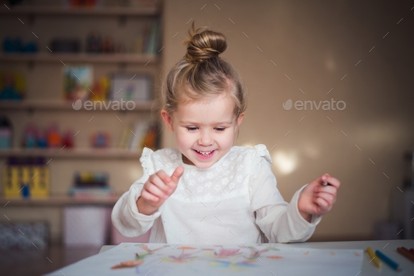happy little girl drawing with crayon at home Stock Photo by shapoval08