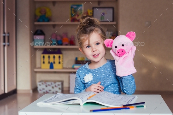 little girl doing homework at home with puppet pig Stock Photo by ...