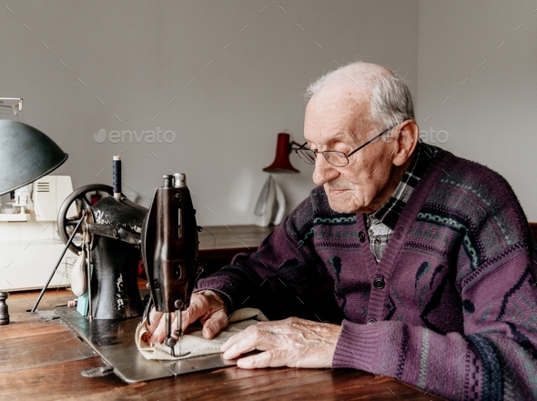 Portrait of an old man in his own shop. Senior man behind a sewing ...