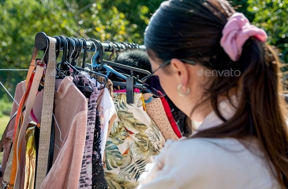 Selective focus photo of woman looking at clothes on a second hand ...
