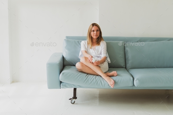 portrait of a young adorable woman in a silk robe with cup of coffee at ...