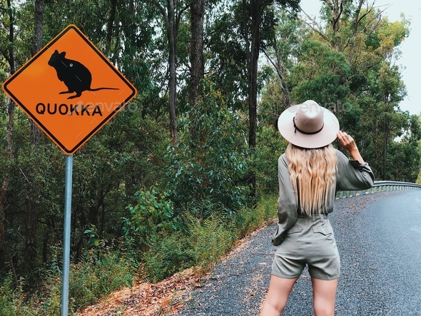 Beautiful blonde traveler girl wearing hat next to quokka sign in ...
