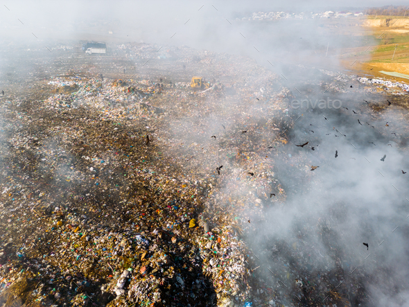 Aerial view of burning trash piles in landfill Stock Photo by collab_media