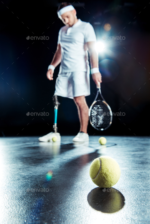 selective focus of tennis ball and paralympic tennis player with racket ...