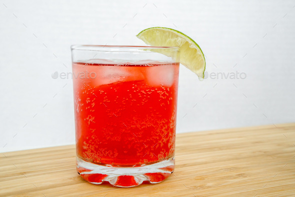 Red sparkling drink with lime slice Stock Photo by phoenixproduction