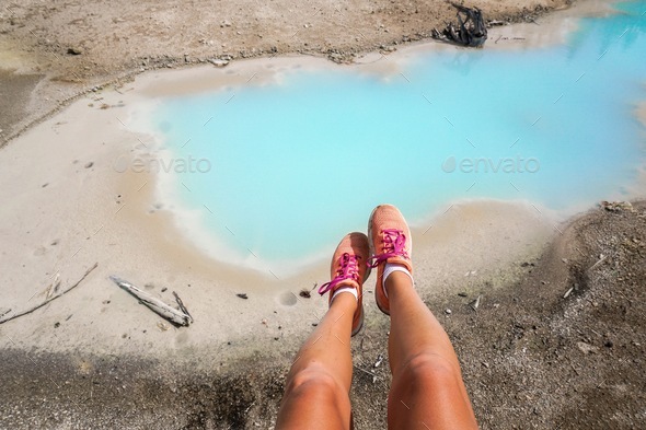 Female legs personal perspective sitting by the volcanic lake in ...