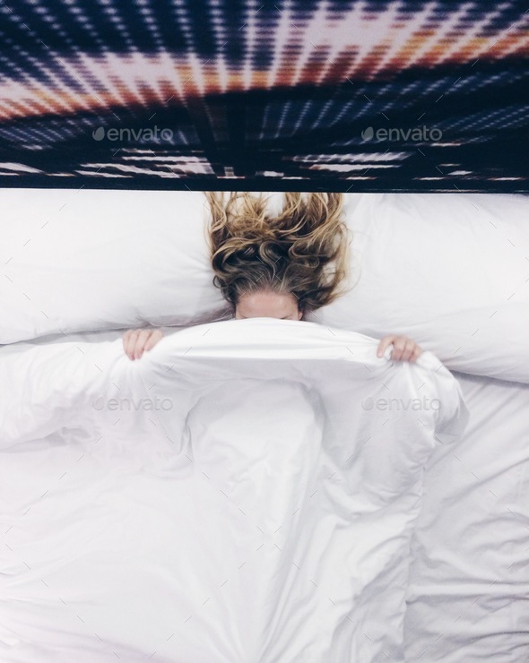 View from above woman laying in bed pulling up the blanket Stock Photo ...