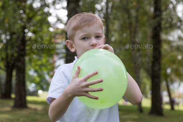 Portrait of a little boy inflating a balloon Stock Photo by Tatiana_Mara