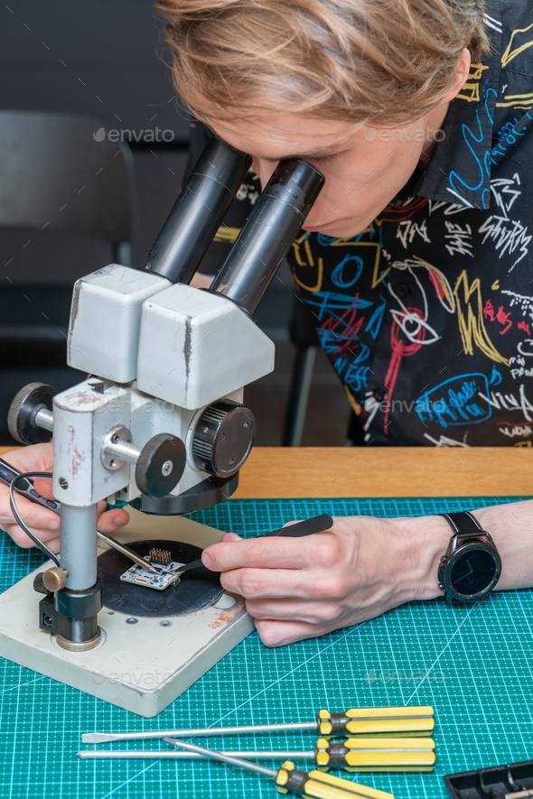 Technician engineer is soldering circuit board of electronic device ...