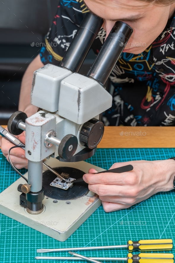 Technician engineer is soldering circuit board of electronic device ...