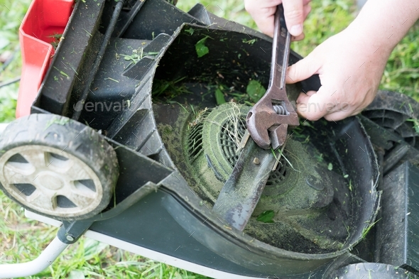 Man repairing a lawn mower Stock Photo by Tatiana_Mara | PhotoDune