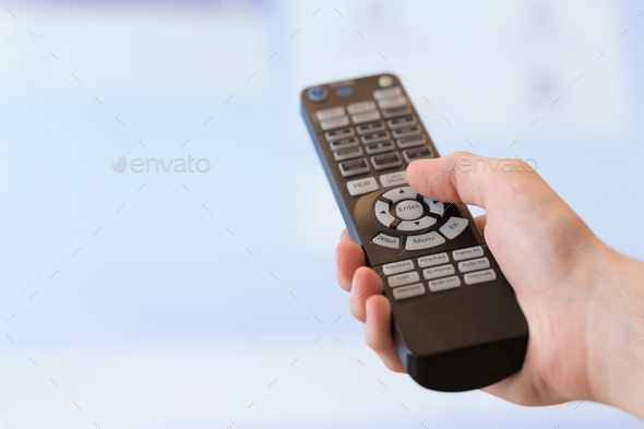 Cropped male hand switches TV channels with a remote control close-up ...