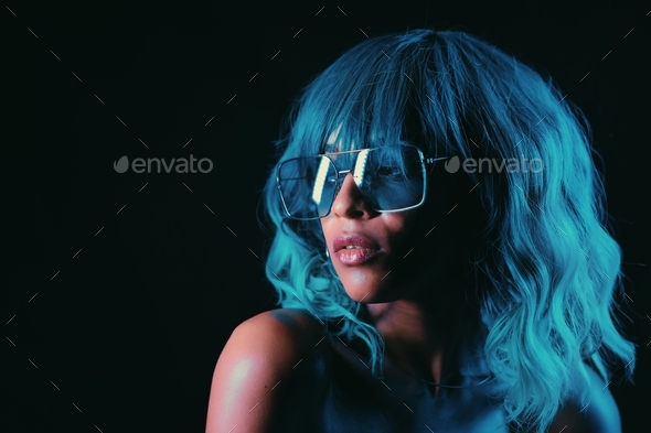 Portrait of alluring blue haired mixed race girl in neon light. Fashion ...