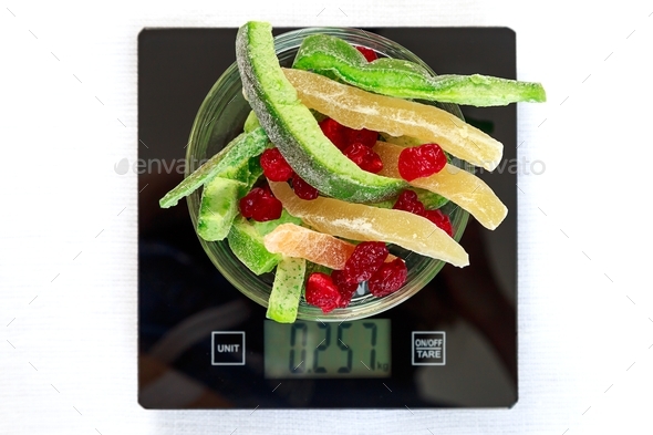 multi-colored dried fruits in a transparent container stand on the ...