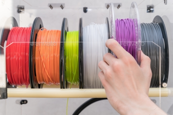 close-up male hand puts a spool of filament into a 3d printer Stock ...