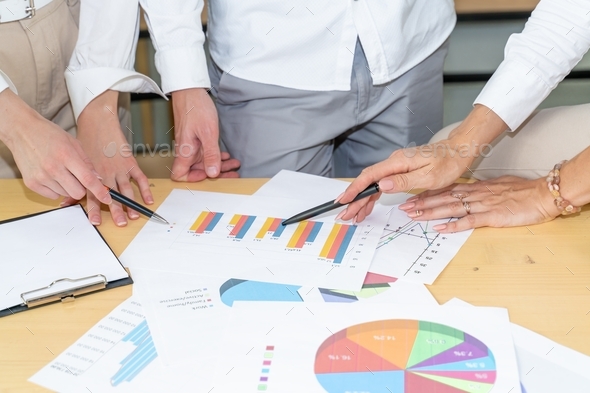 People's hands over the table with charts and graphs closeup. Business ...