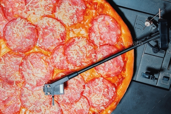 . Italian pizza with salami sausage and cheese spinning on turntable ...