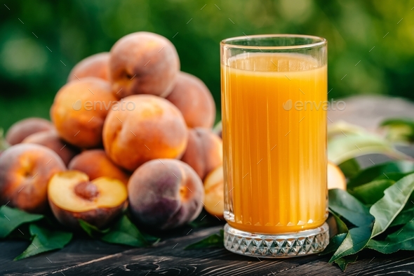 Appetizing photo of ripe peaches on table with glass of freshly ...