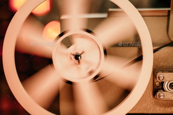 8mm movie projector playing at theater. White reel or can with tape ...