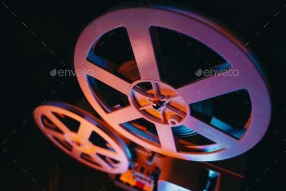 Film reels turning. Analog player, cans with tape. Retro old-fashioned ...