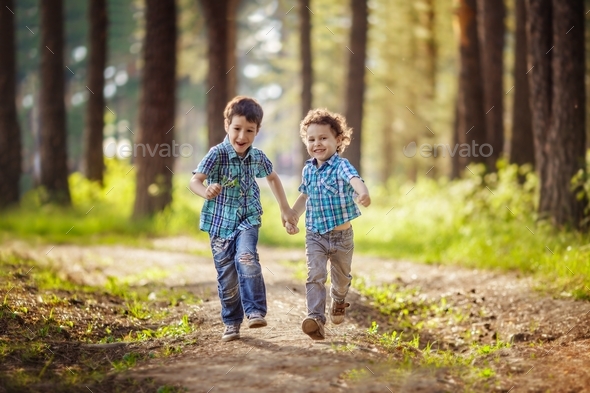 Two real brothers siblings walking together in forest Stock Photo by ...