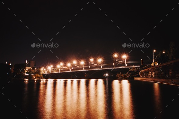 Beautiful night. Bridge and river with lights Stock Photo by Kohanova