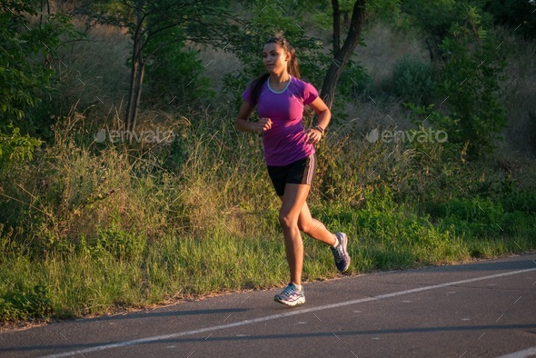 Portrait of sporty young beautiful woman in fitness wear running on ...