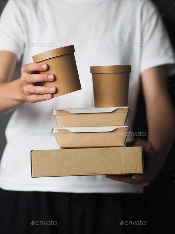 Anonymous young woman in white t-shirt holding stack food delivery ...