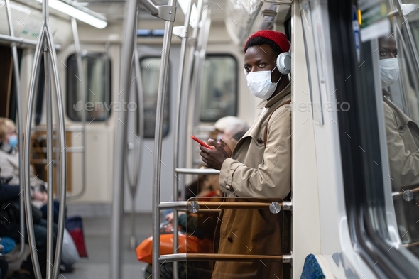 Afro-American passenger man stand in subway train, wear face medical ...